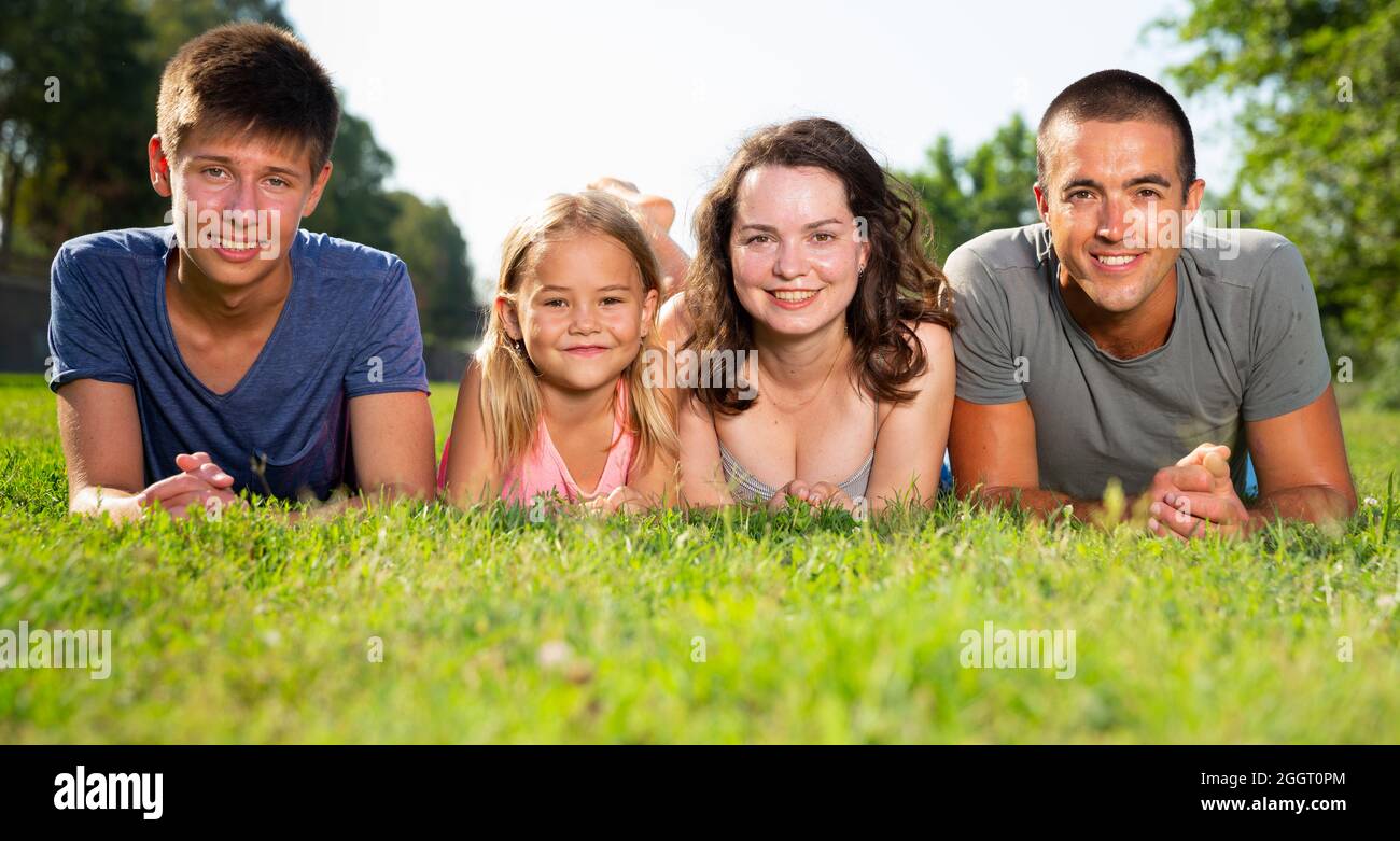 Friendly family lying on green lawn Stock Photo - Alamy