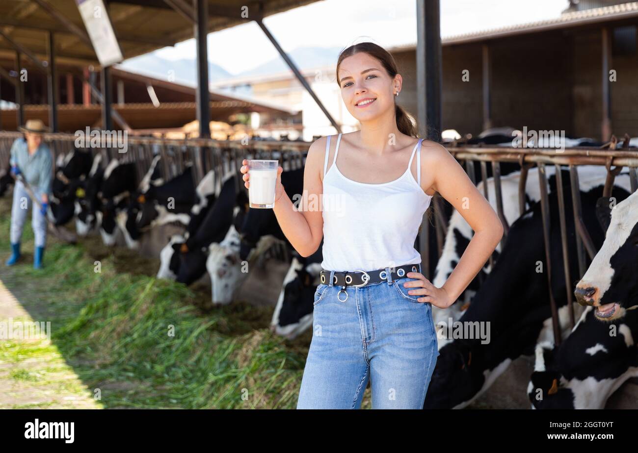 Female milker posing with glass of milk on dairy farm Stock Photo - Alamy