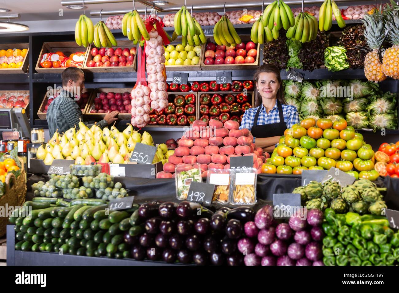 woman seller stands near counter with fruits and vegetables Stock Photo ...