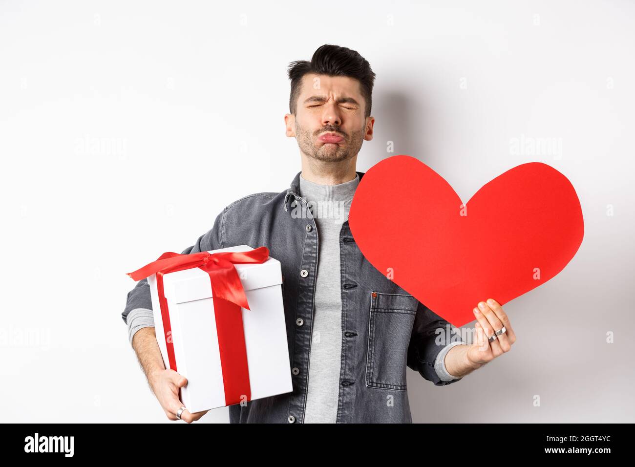 Sad and heartbroken man being rejected, crying and holding red heart ...