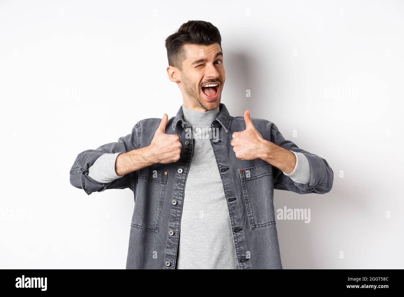 Happy young man with moustache winking and showing thumbs-up ...