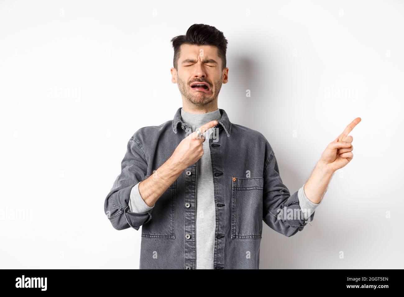 Crying man whining and complaining, pointing fingers right at sad news ...