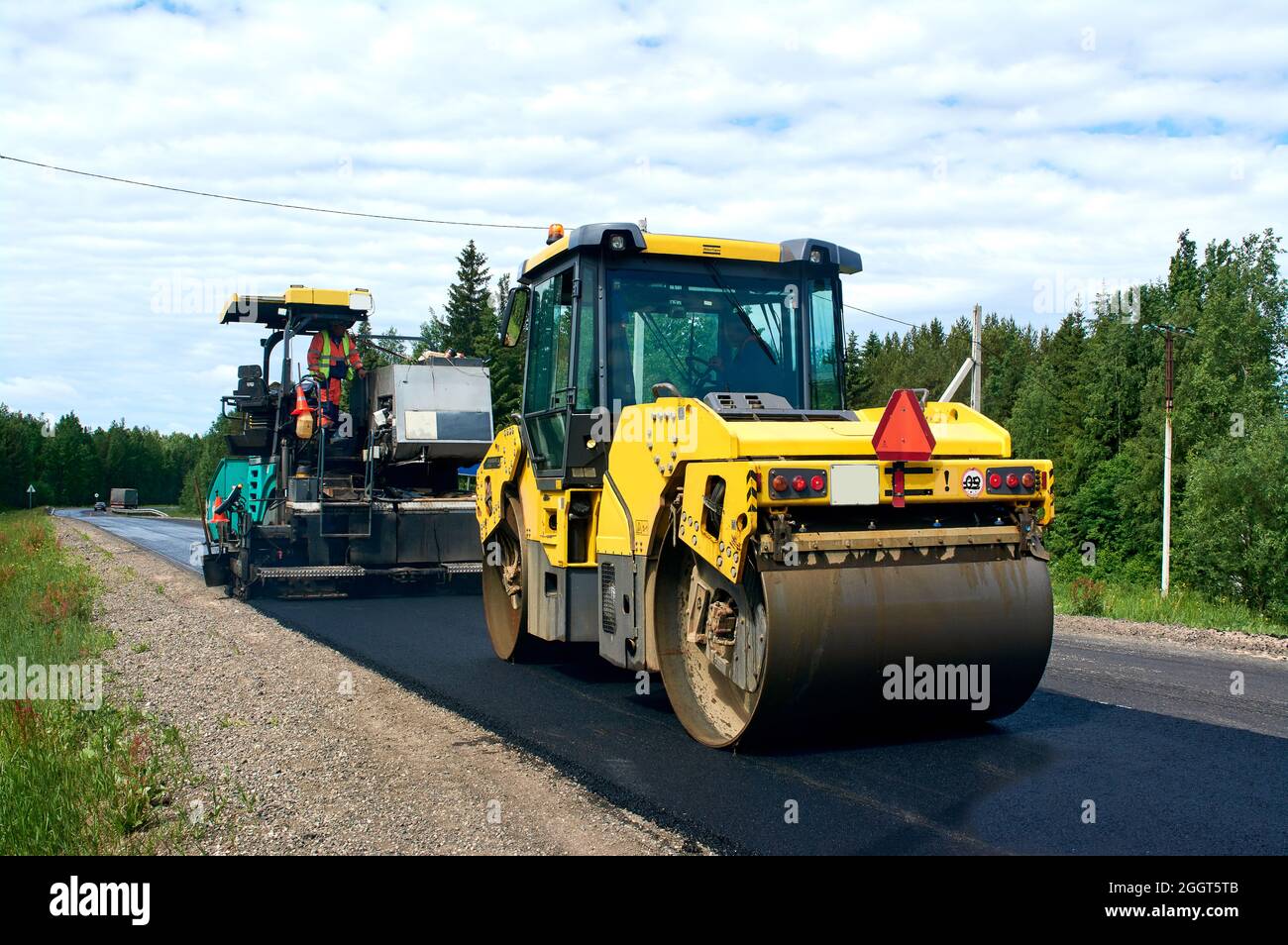 laying of asphalt with the help of an asphalt paver and sealing with a ...