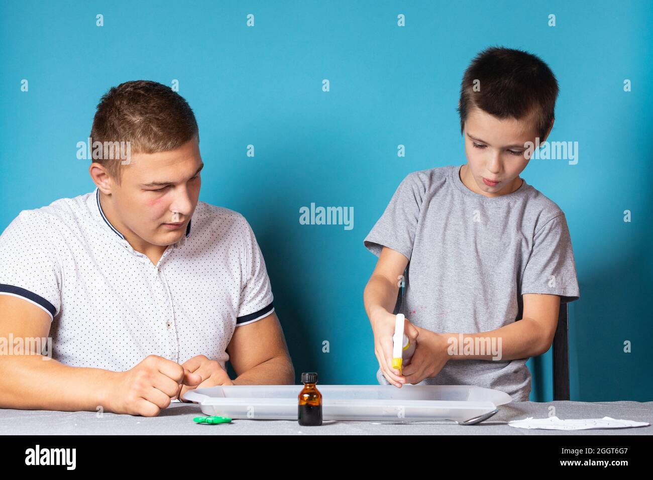 Dad and son are conducting chemical experiments, observing the change ...