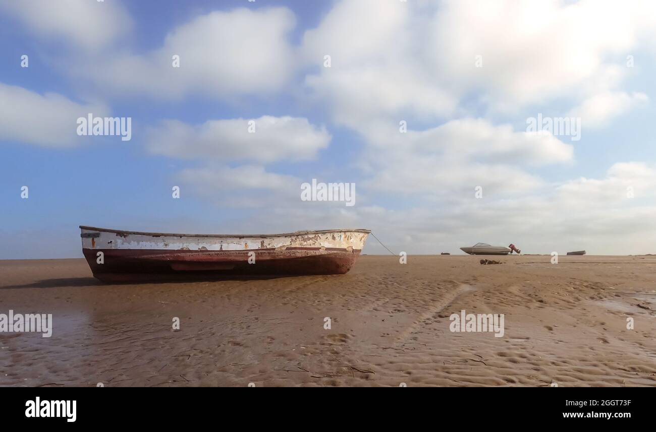 A traditional fishing boat rest on a sand beach. Small wooden rowing ...