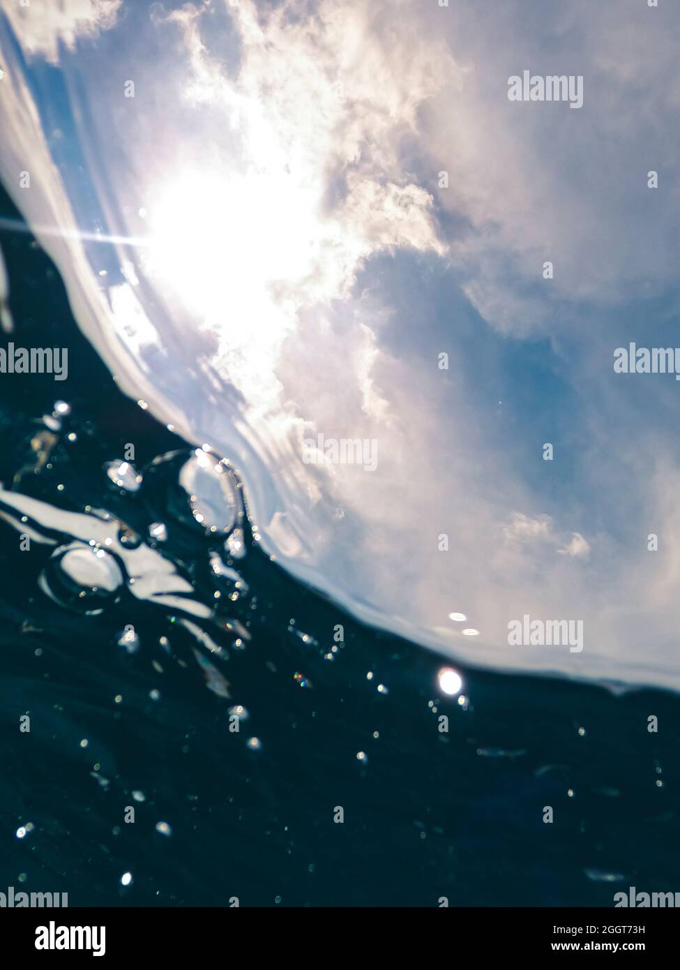 Sun light beams shining from above coming through the deep blue water ...