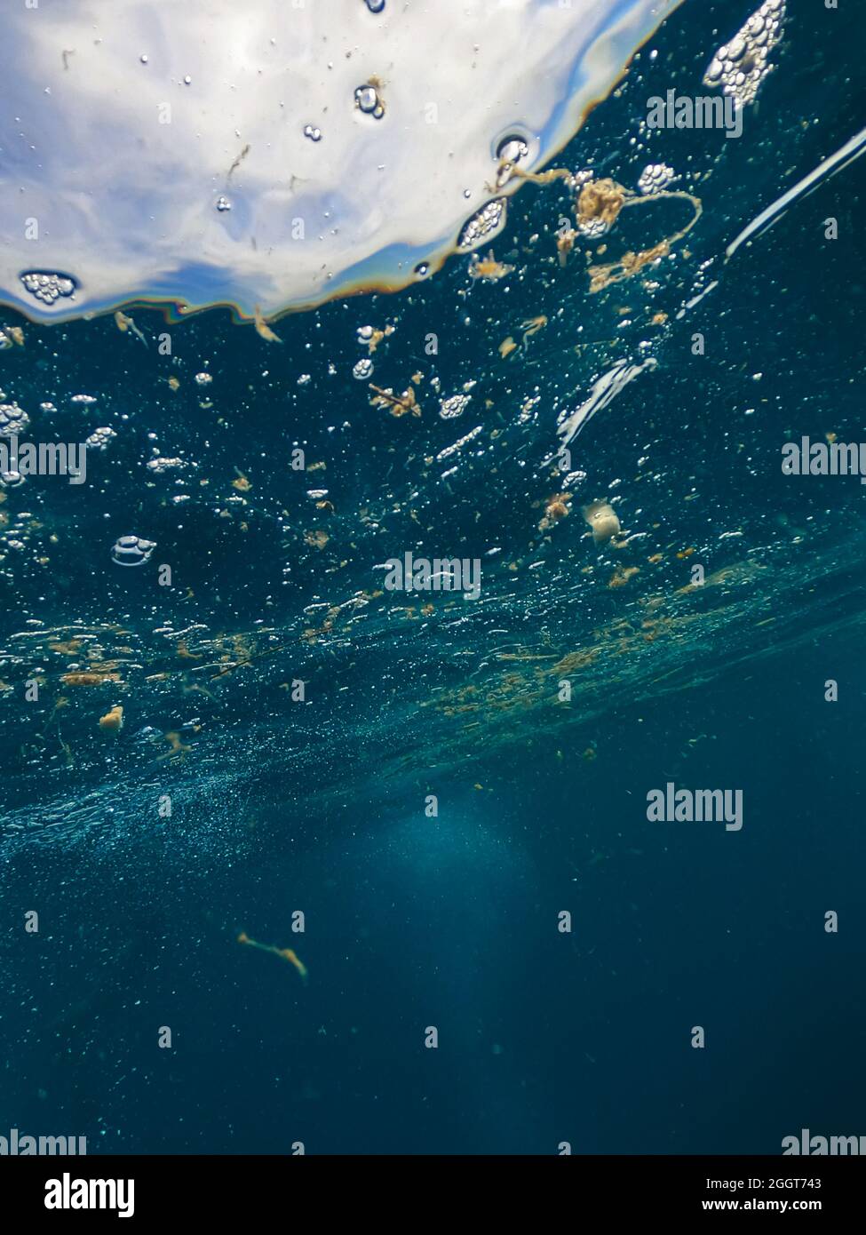 Sun light beams shining from above coming through the deep blue water ...