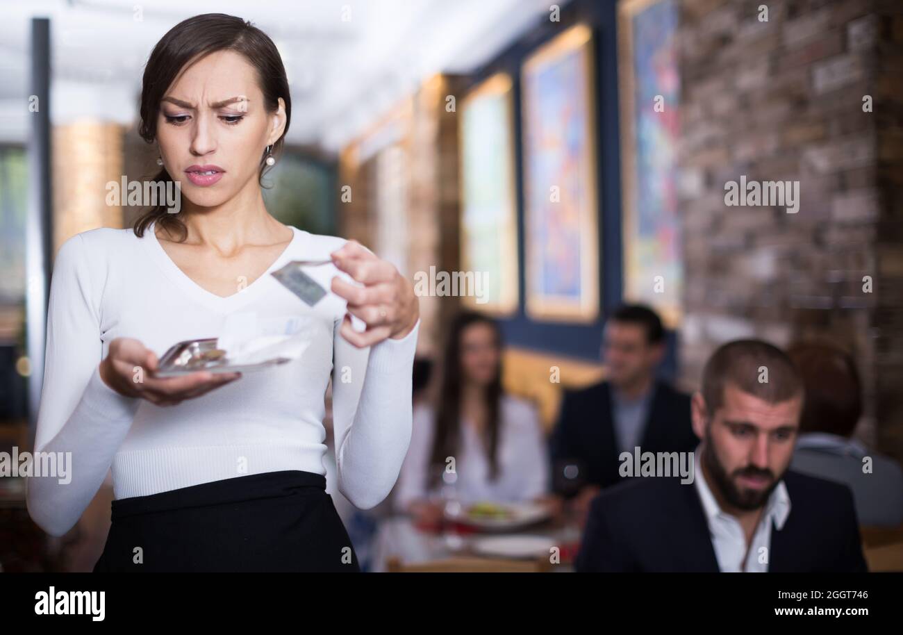 annoyed waitress standing with tray with tips money Stock Photo - Alamy