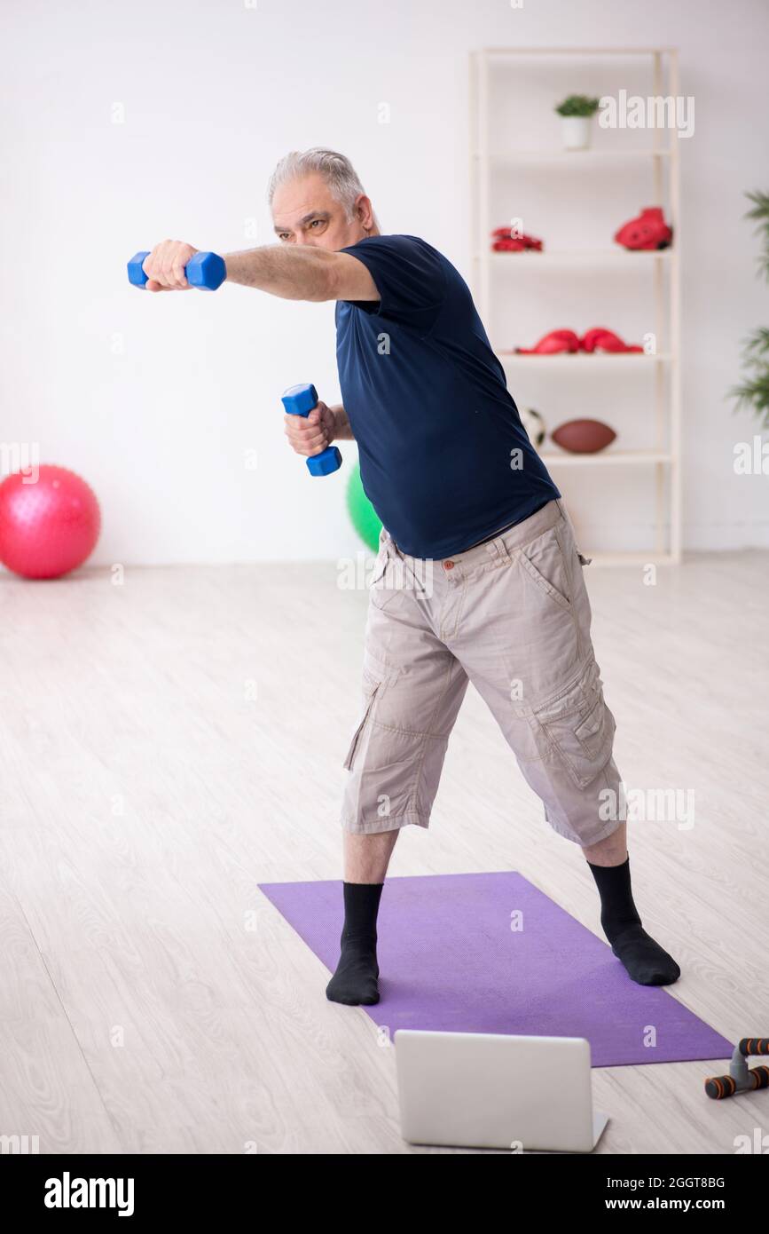 Old man doing sport exercises at home Stock Photo - Alamy