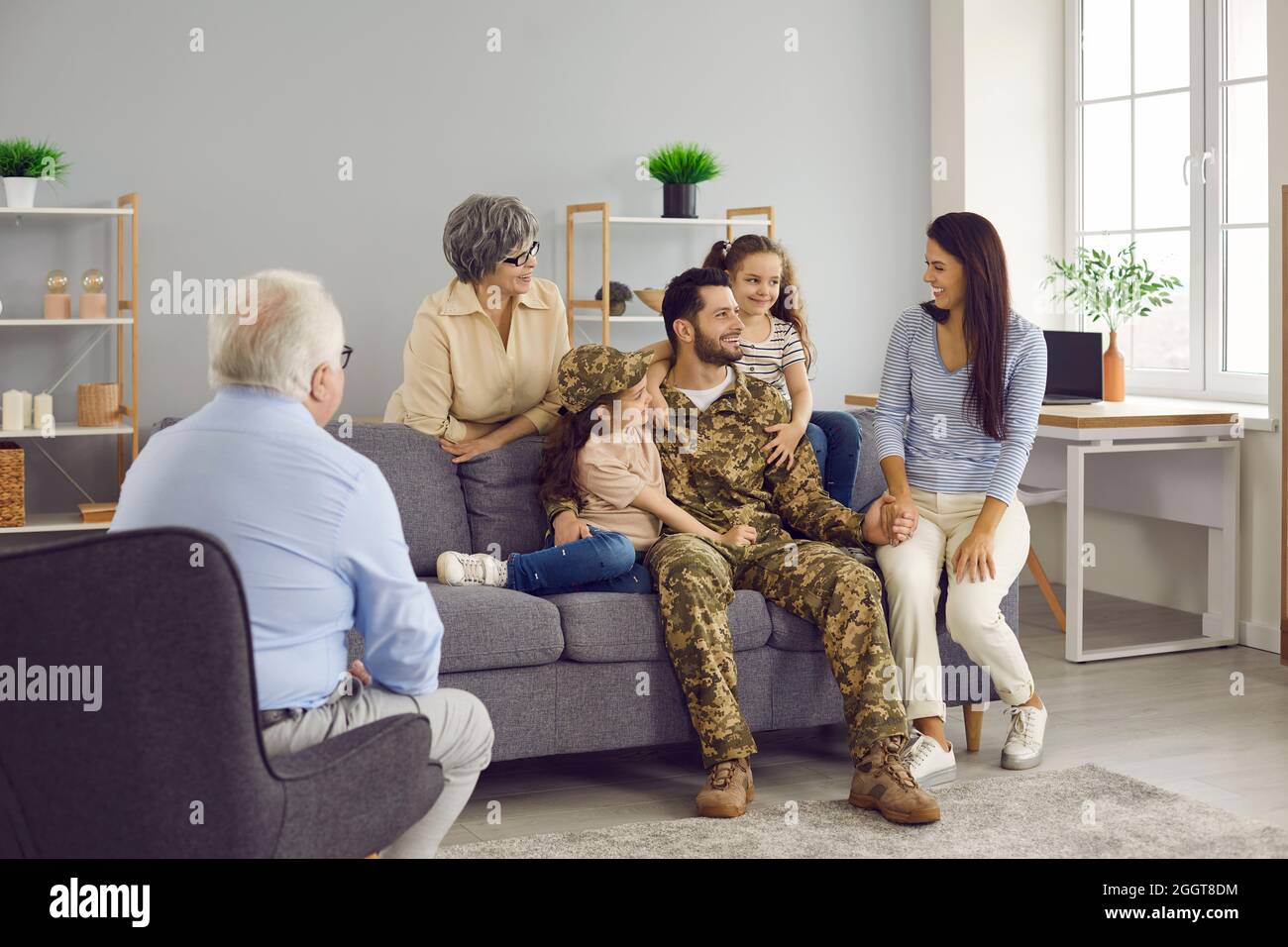 Happy soldier man is talking with his family after returning from ...