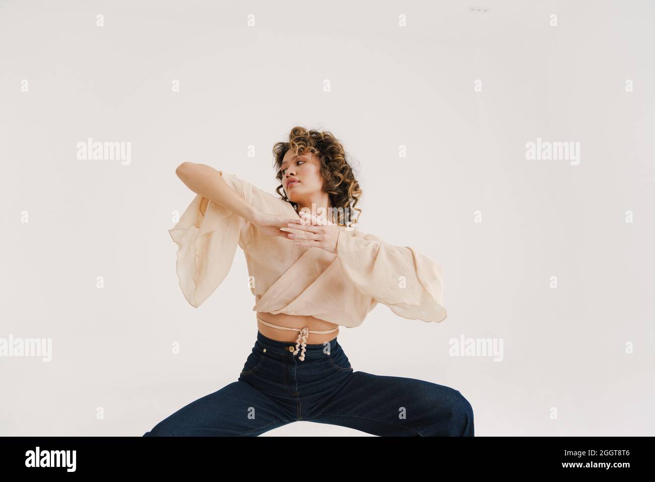 Young hispanic woman with curly hair dancing on camera isolated over ...