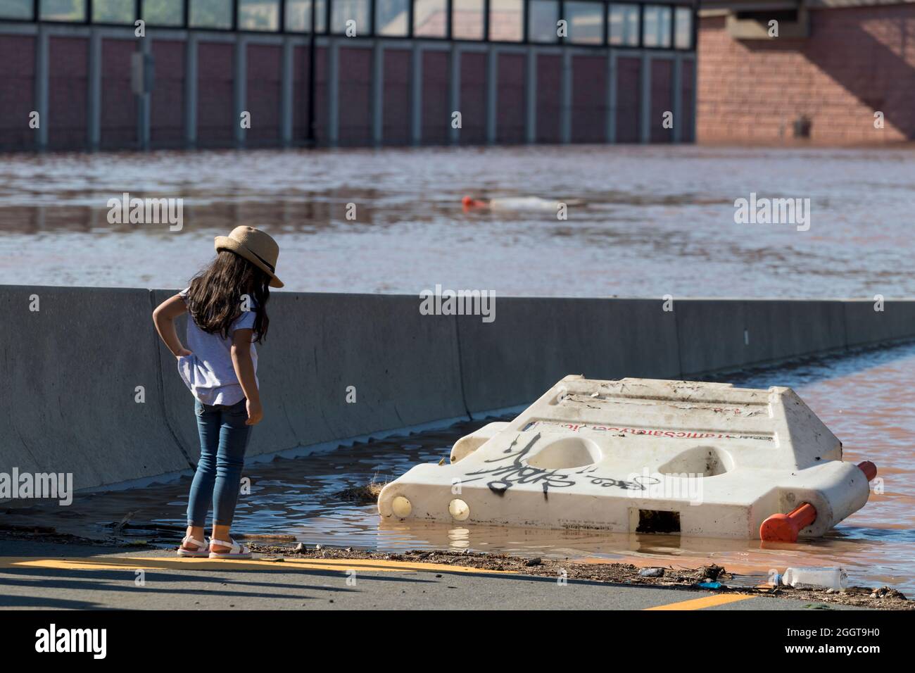 Child views flood damage and debris from a closed highway ramp in the ...