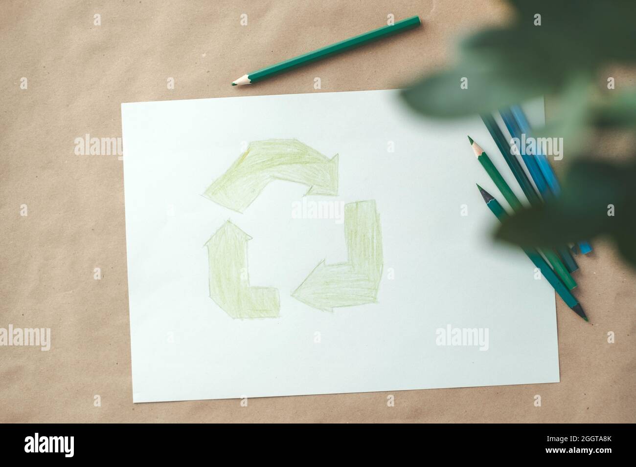 Children's drawing with the symbol of reuse on the table. reducing ...