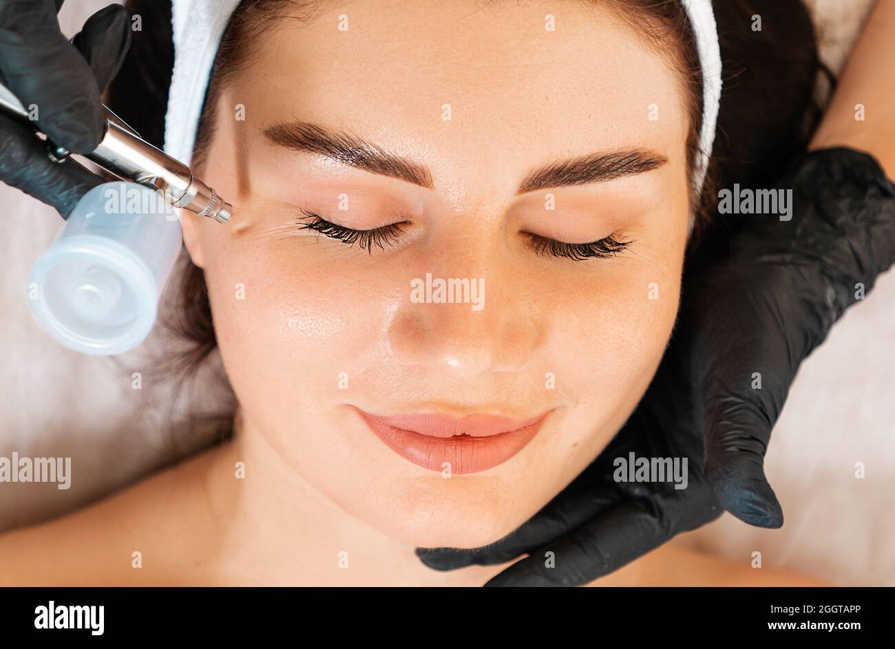 Face Beauty Treatment. Cosmetologist does a client's face gas-liquid ...