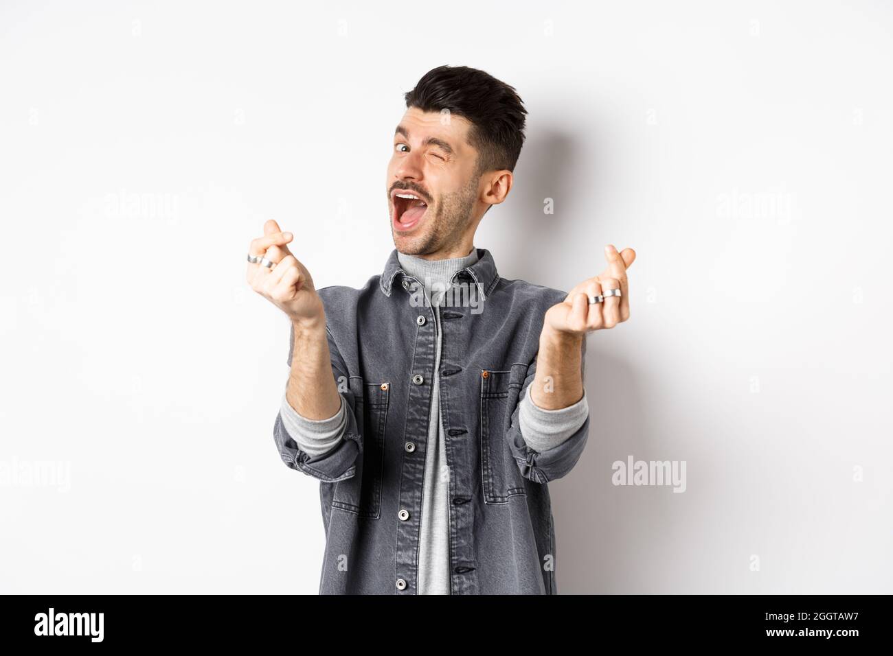 Funny guy winking and showing hand hearts sign, feeling romantic and ...
