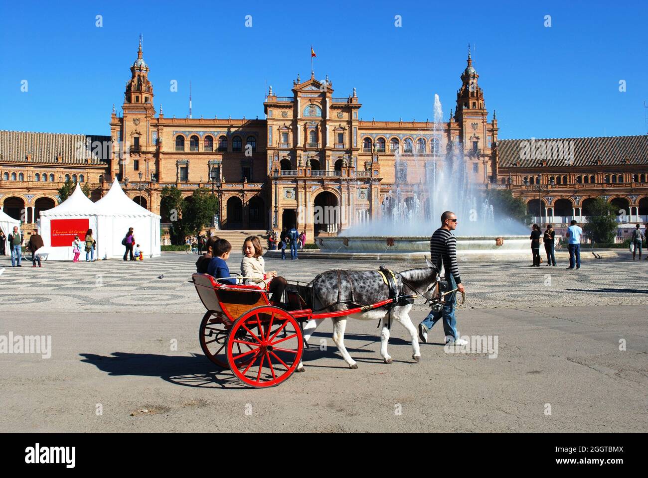Donkey carriage carrying three children in the Plaza de Espana, Seville ...