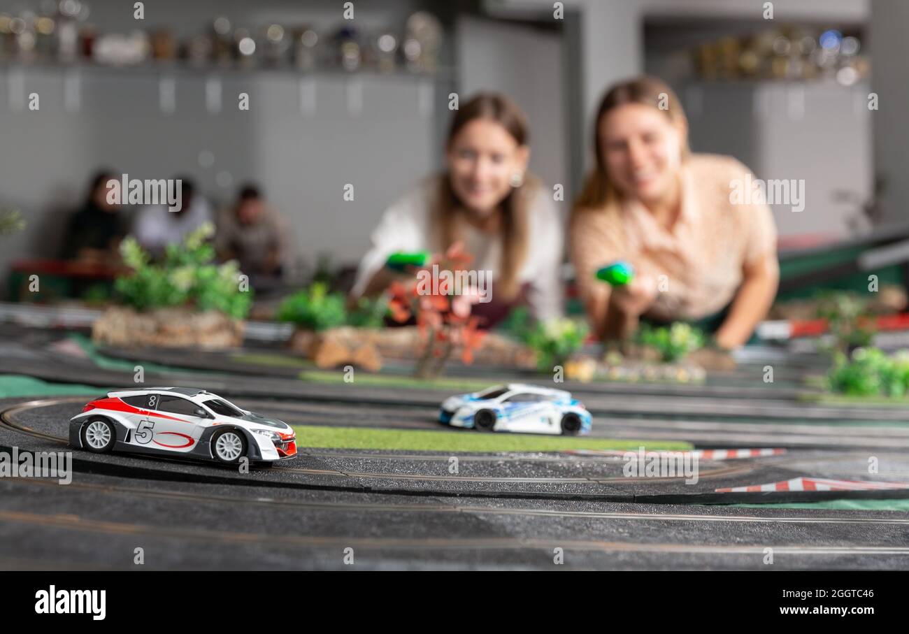 women players playing with slot car racing track Stock Photo - Alamy
