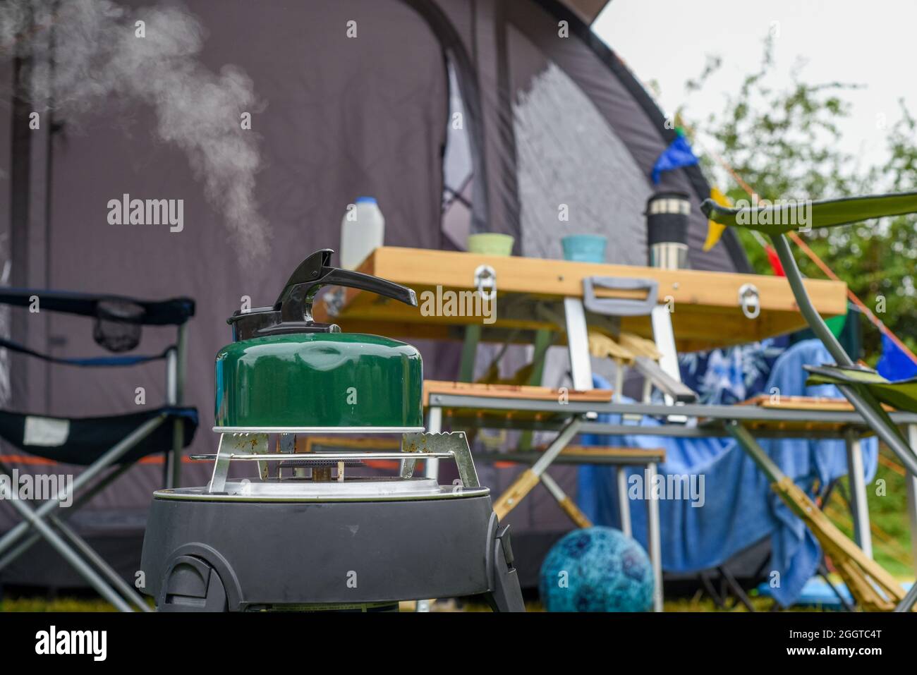 Boiling a kettle outside a tent on a campsite in the morning Stock ...