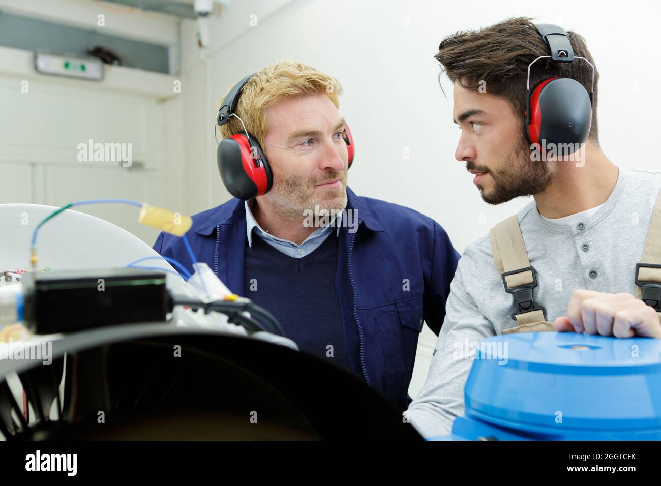two men in workwear in a carpenters workshop Stock Photo - Alamy