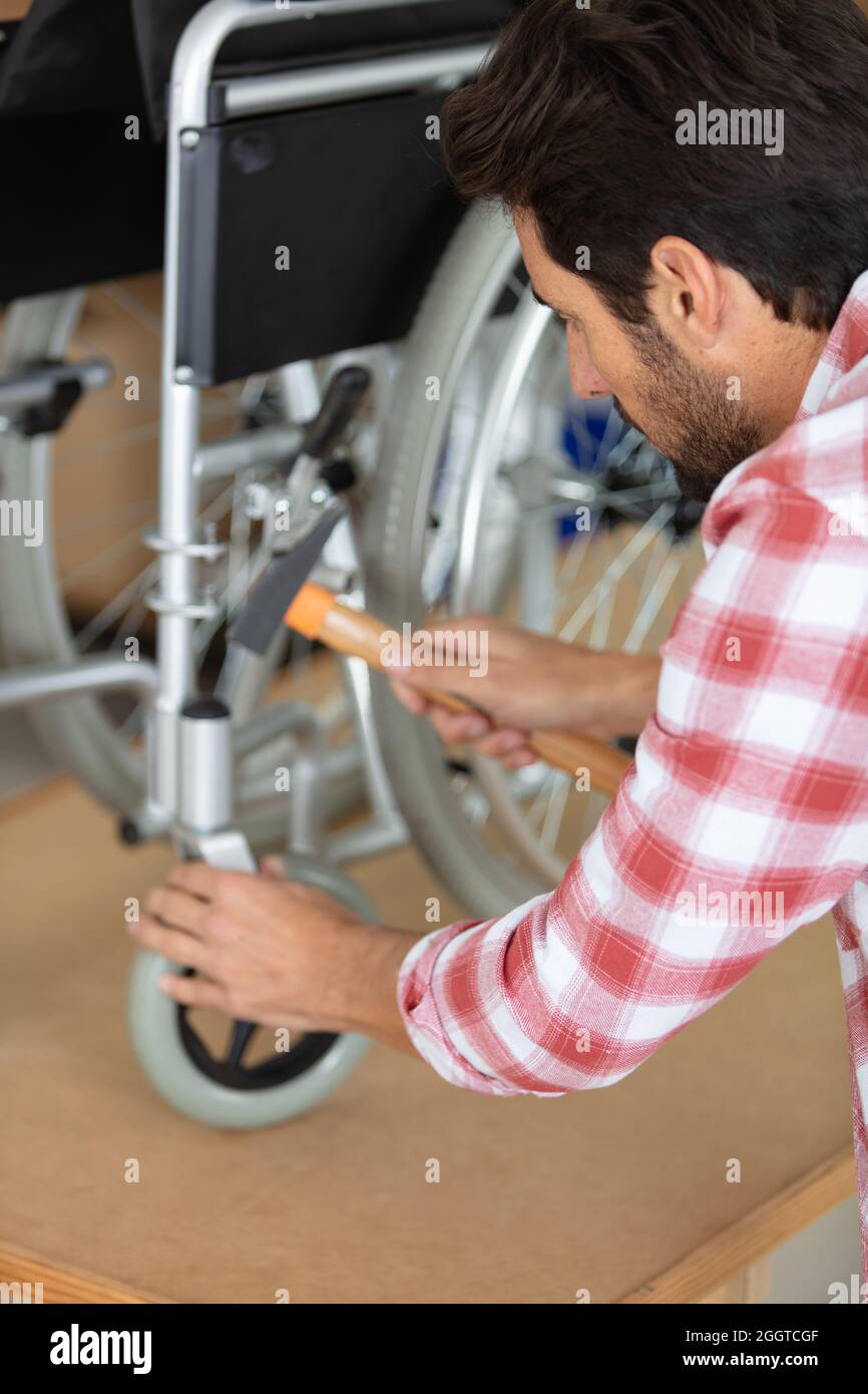 man is repairing a wheelchair at workshop Stock Photo - Alamy