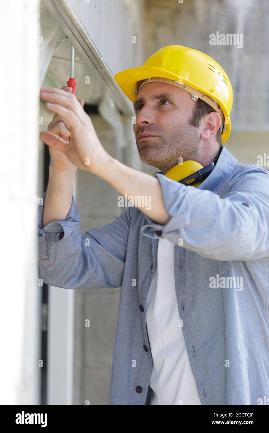 man holding a screw driver tool in white background Stock Photo - Alamy