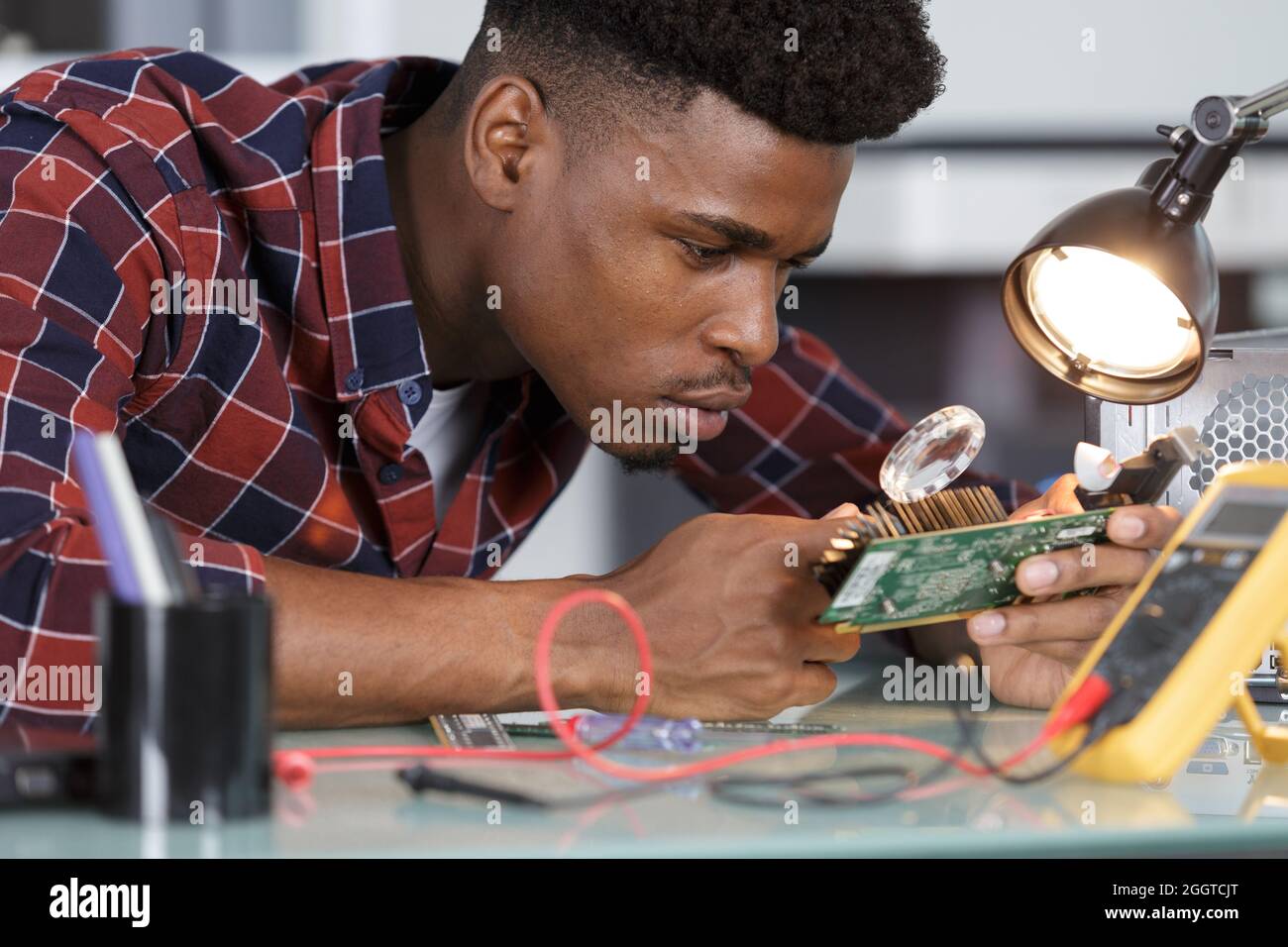 computer technician looking through magnifying glass Stock Photo - Alamy