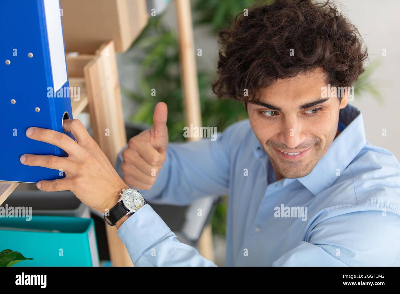 a man reaching for a folder in a cabinet Stock Photo - Alamy
