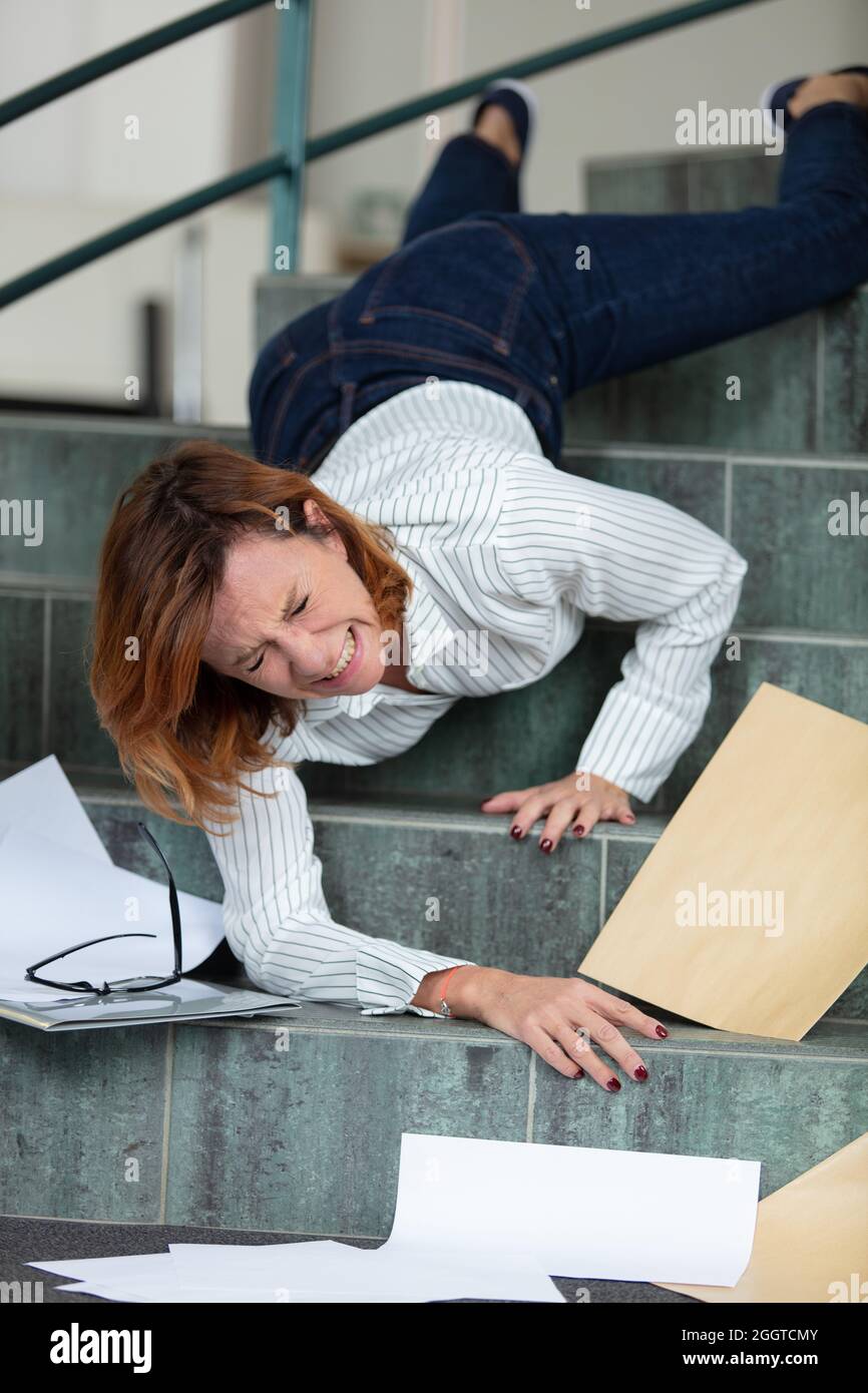 mature businesswoman falling on stairs inside office building Stock ...