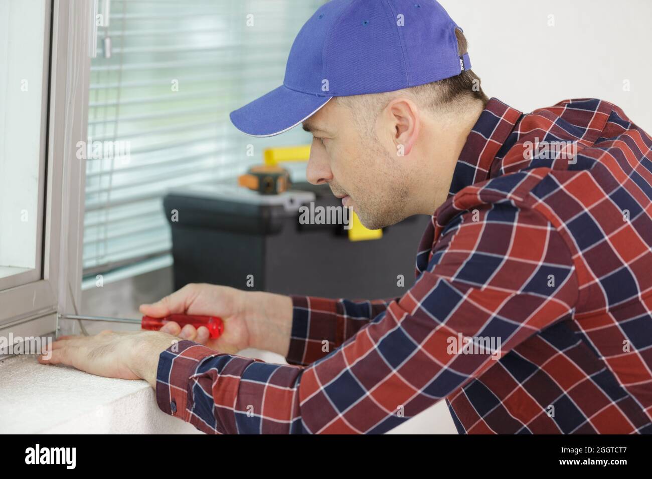 repairman fixing window frame in room Stock Photo - Alamy