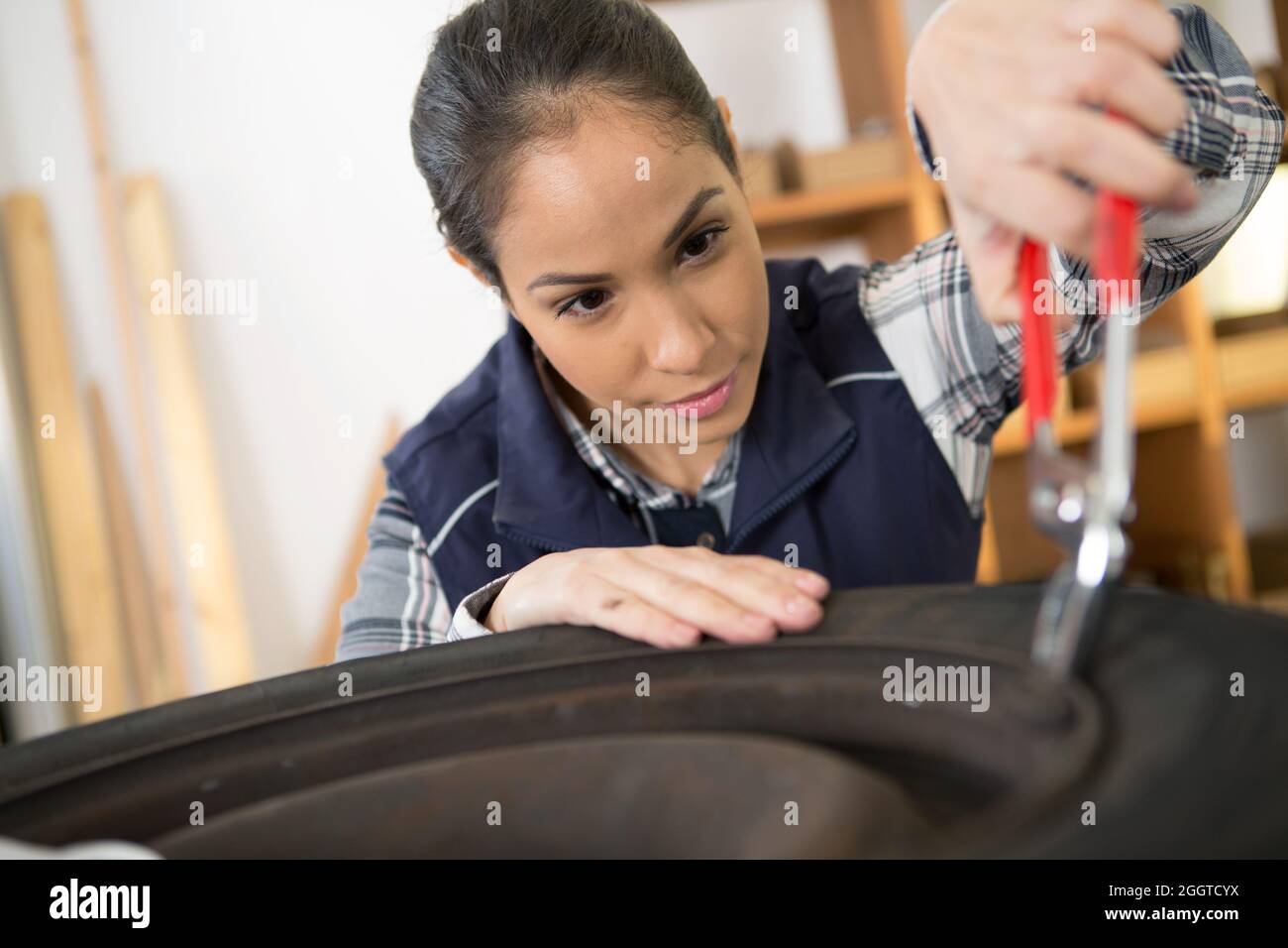 female mechanic using balance wheel weight remover Stock Photo - Alamy