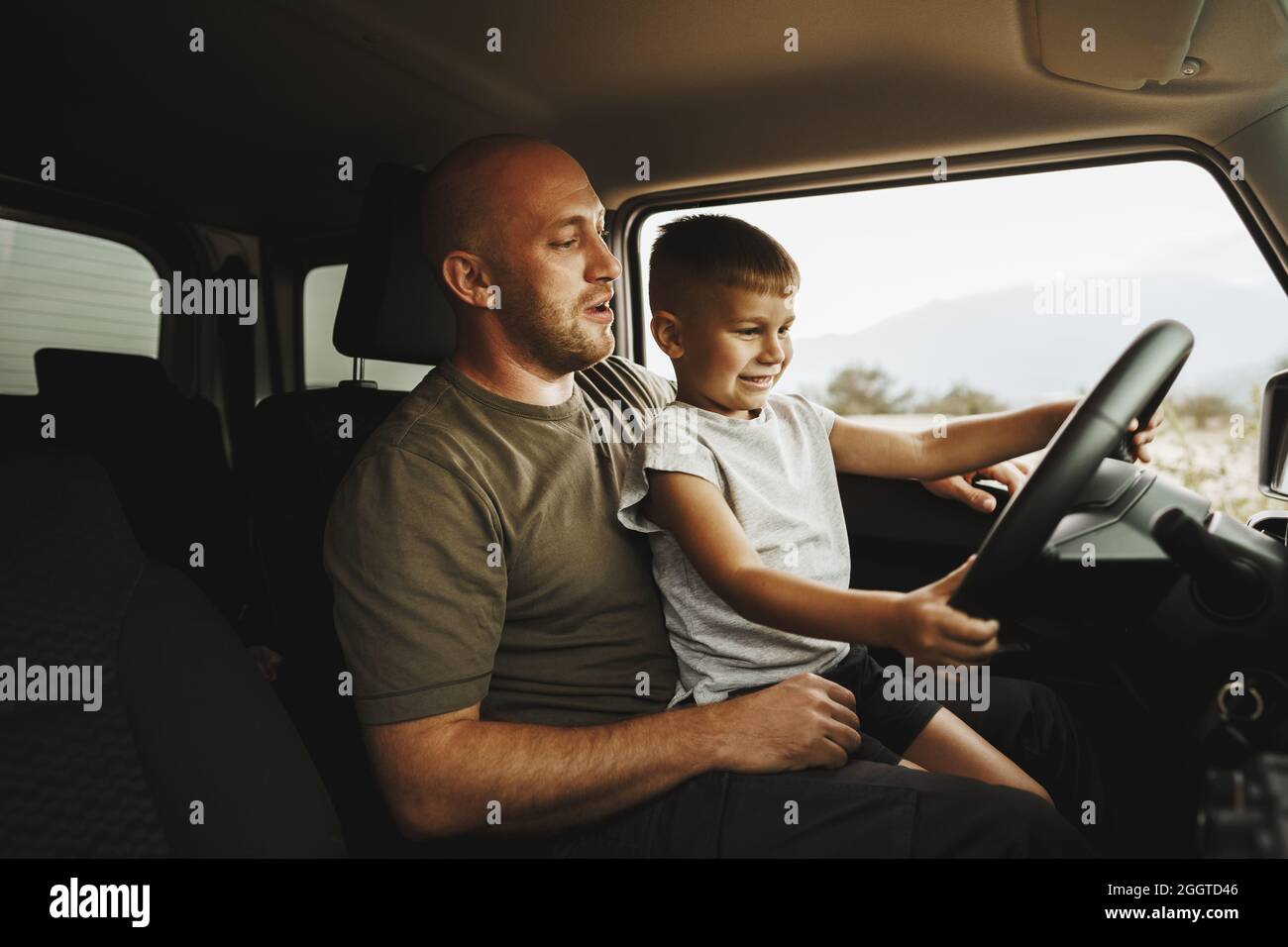 Father teaches little son to drive on road trip Stock Photo - Alamy