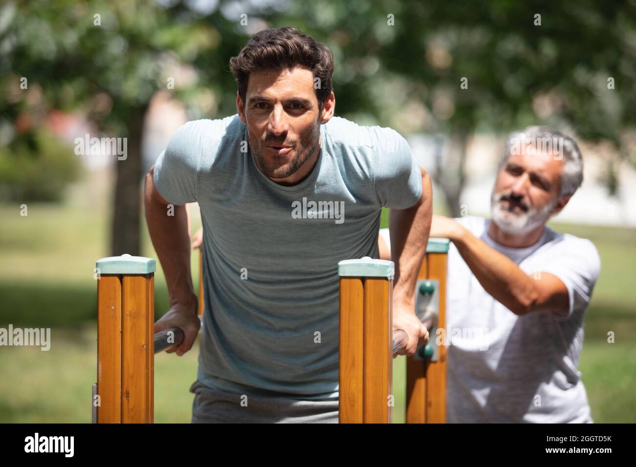 two strong and competitive men exercising on monkey bars Stock Photo ...