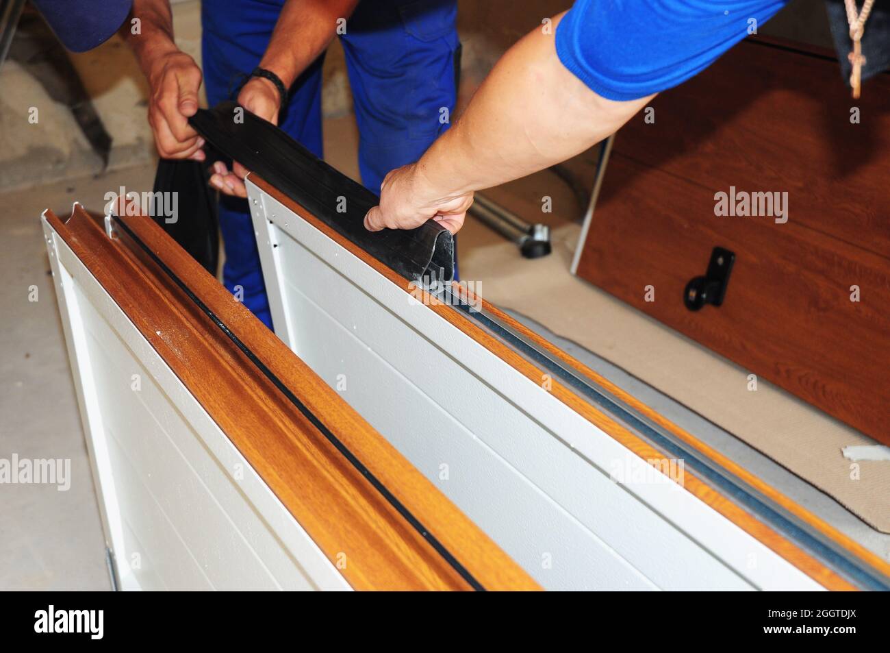 Contractors repair garage door panel replacement Stock Photo - Alamy