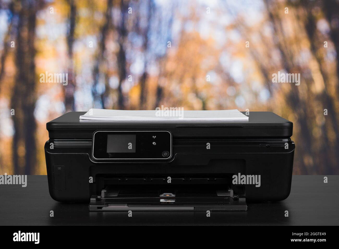 Compact laser printer on black desk against blurred background Stock ...