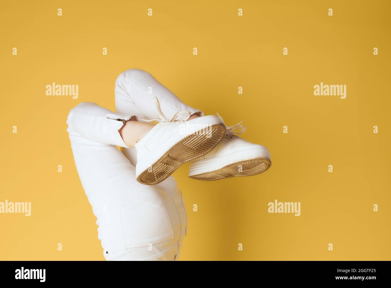 inverted legs in white sneakers fashion modern style yellow background ...