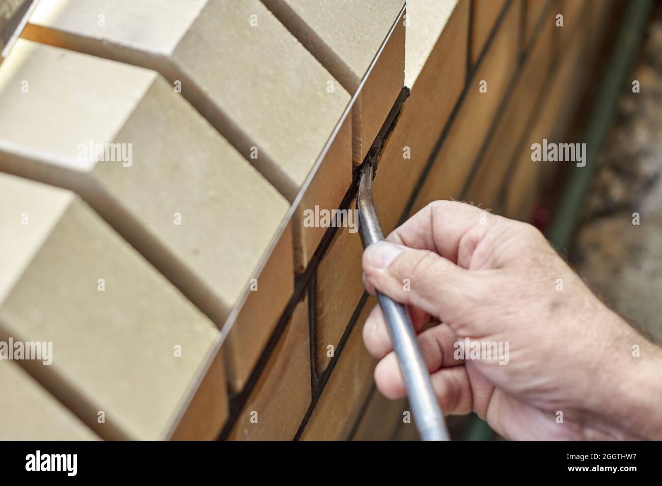 Bricklayer builds new fence from facing bricks. Alignment of inter ...