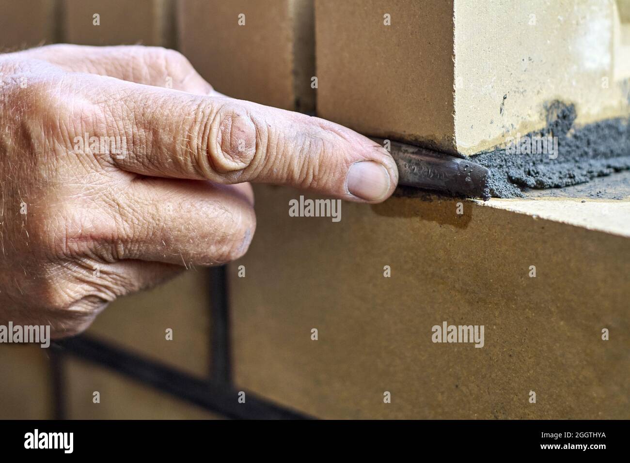 Bricklayer builds new fence from facing bricks. Alignment of inter ...