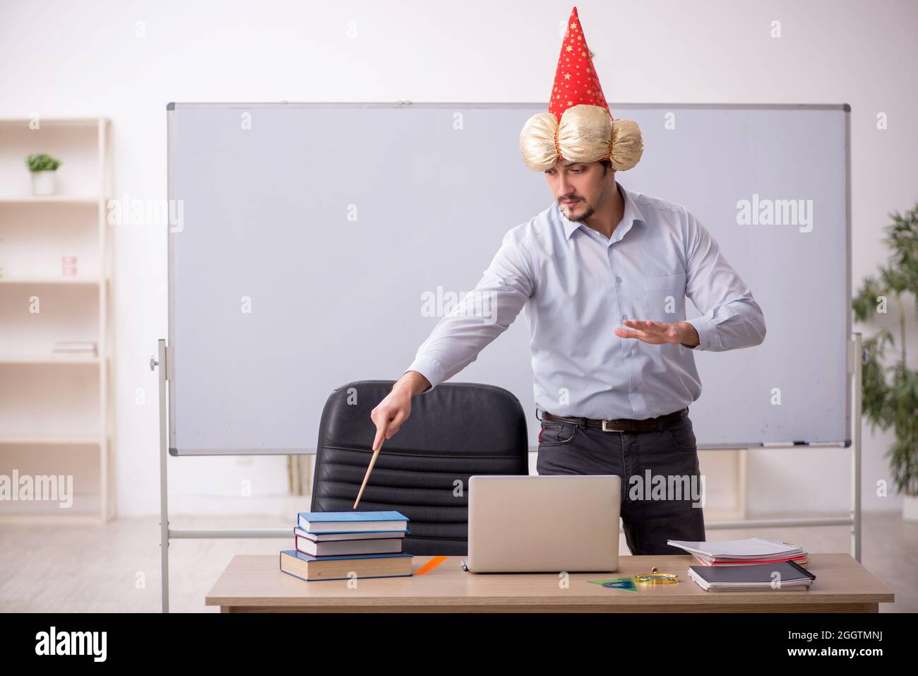 Funny young teacher magician in the classroom Stock Photo - Alamy