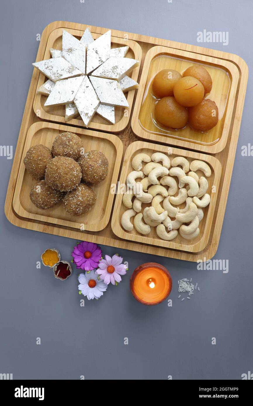 Diwali Diya, Sweets or Mithai, and flowers are arranged as a festive ...