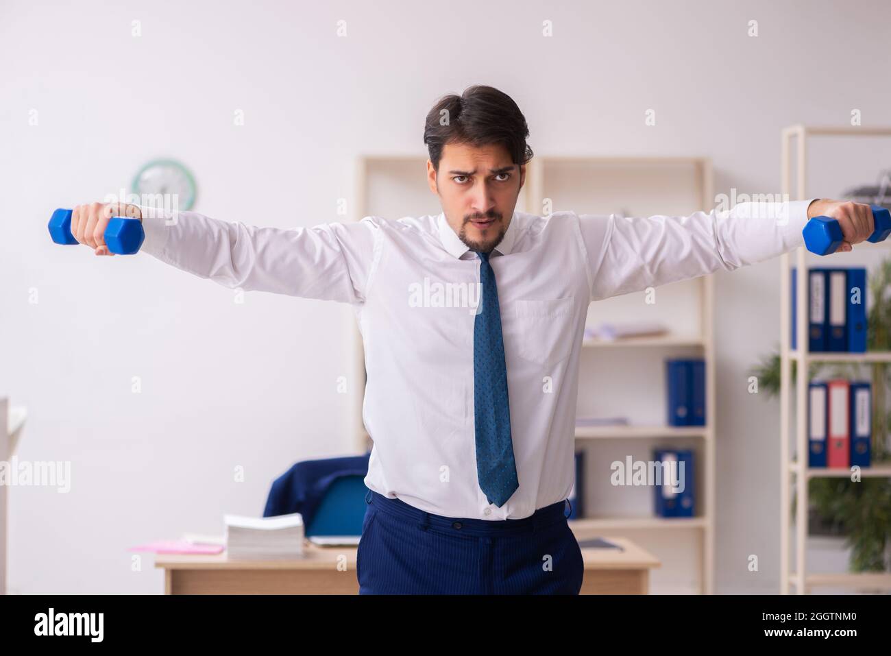 Young businessman employee doing sport exercises during break Stock ...