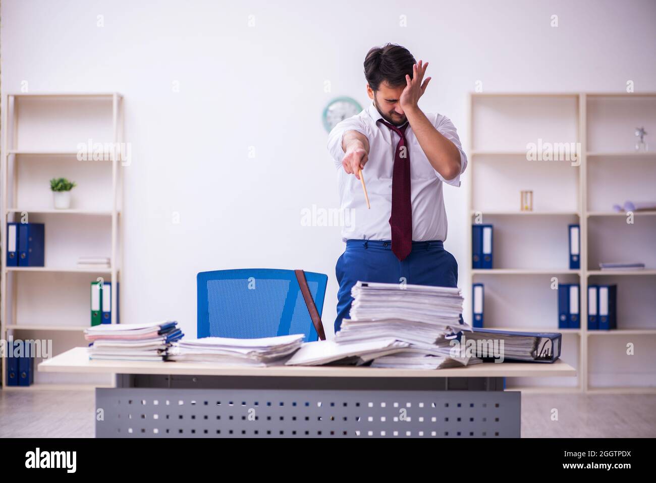 Funny young employee magician and too much work in the office Stock ...