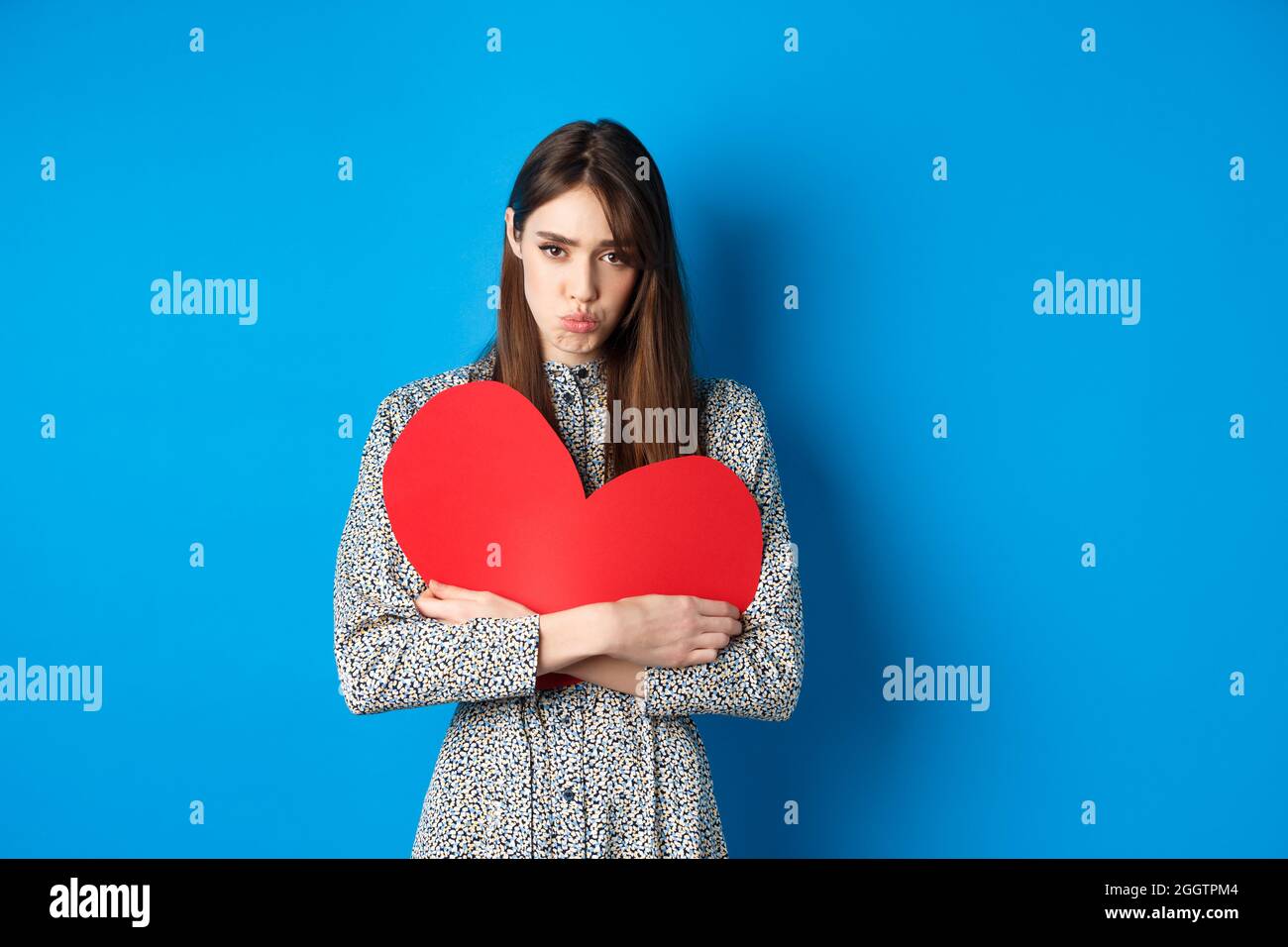 Valentines day. Sad and gloomy caucasian girl pucker lips and looking ...