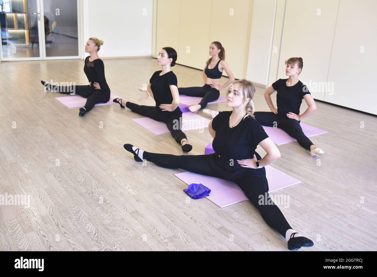 Five dancer girls warming up with stretching exercises for flexibility ...
