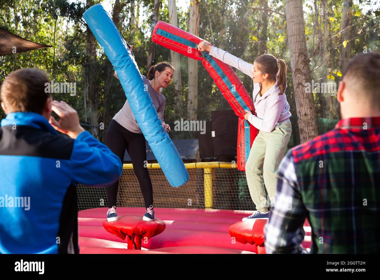 Female friends fighting by inflatable logs Stock Photo - Alamy