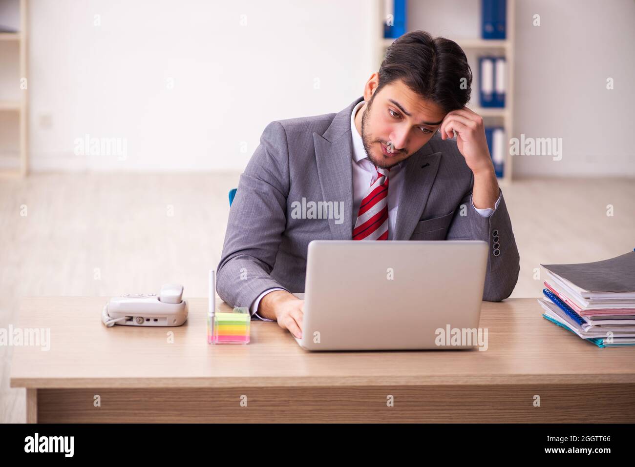 Young male employee working at workplace Stock Photo - Alamy