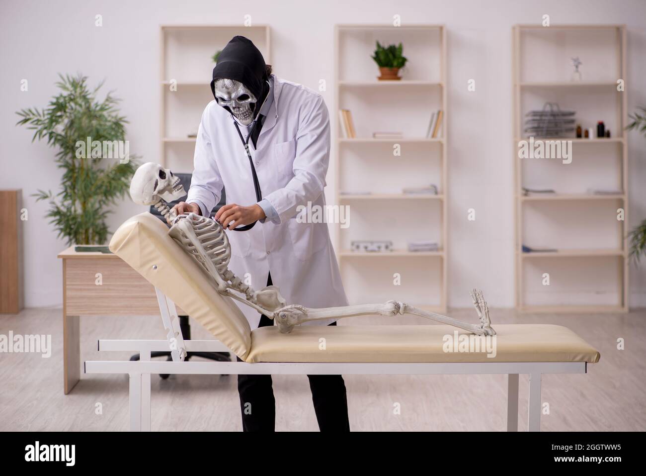 Devil doctor examining skeleton patient in the clinic Stock Photo - Alamy