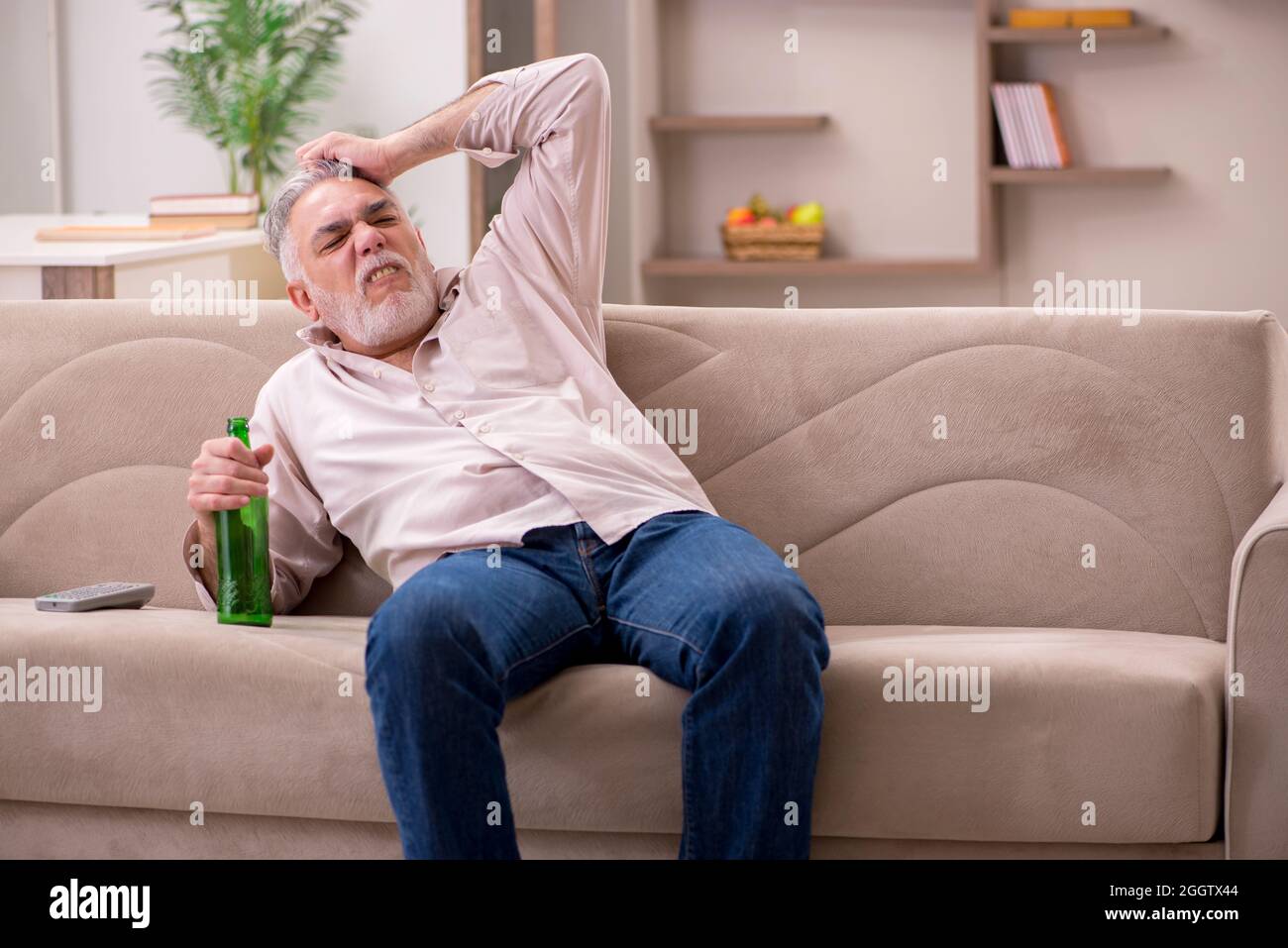 Aged man drinking alcohol at home Stock Photo - Alamy