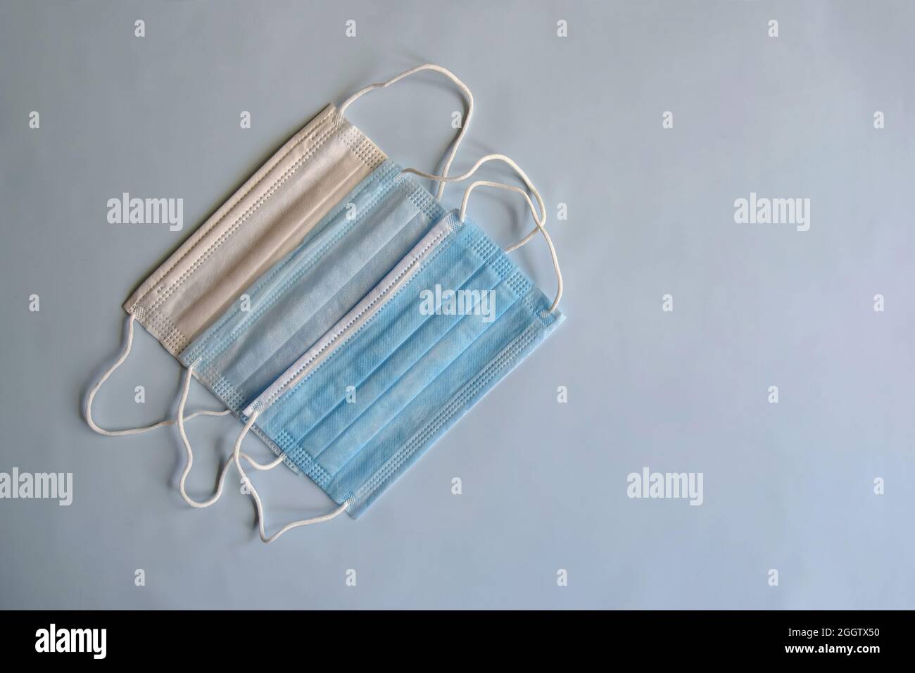 Three medical masks on light blue background. Virus protection remedies ...
