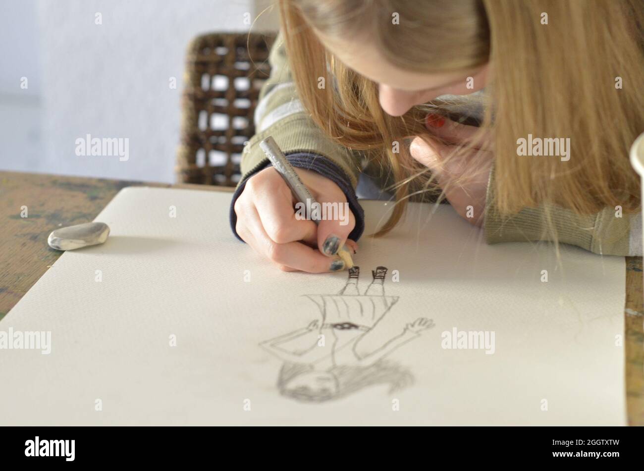 Young blond girl drawing on a paper Stock Photo - Alamy