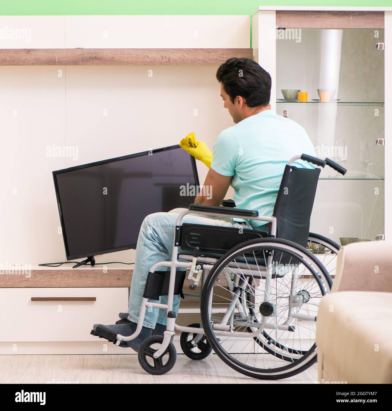 The disabled man on wheelchair cleaning house Stock Photo - Alamy